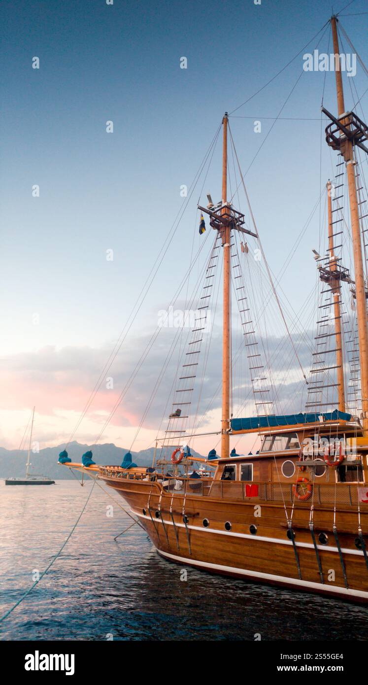 Vertical photo of beautiful wooden historical ship in port at sunset ...