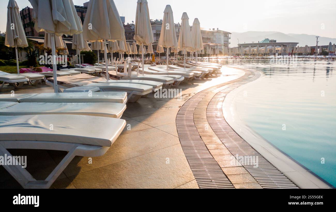 Toned photo of empty sun bed at poolside at early morning. Nobody at ...