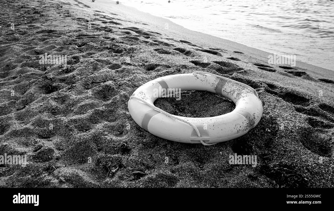 Black and white photo of plastic life saving ring lying on the sea ...