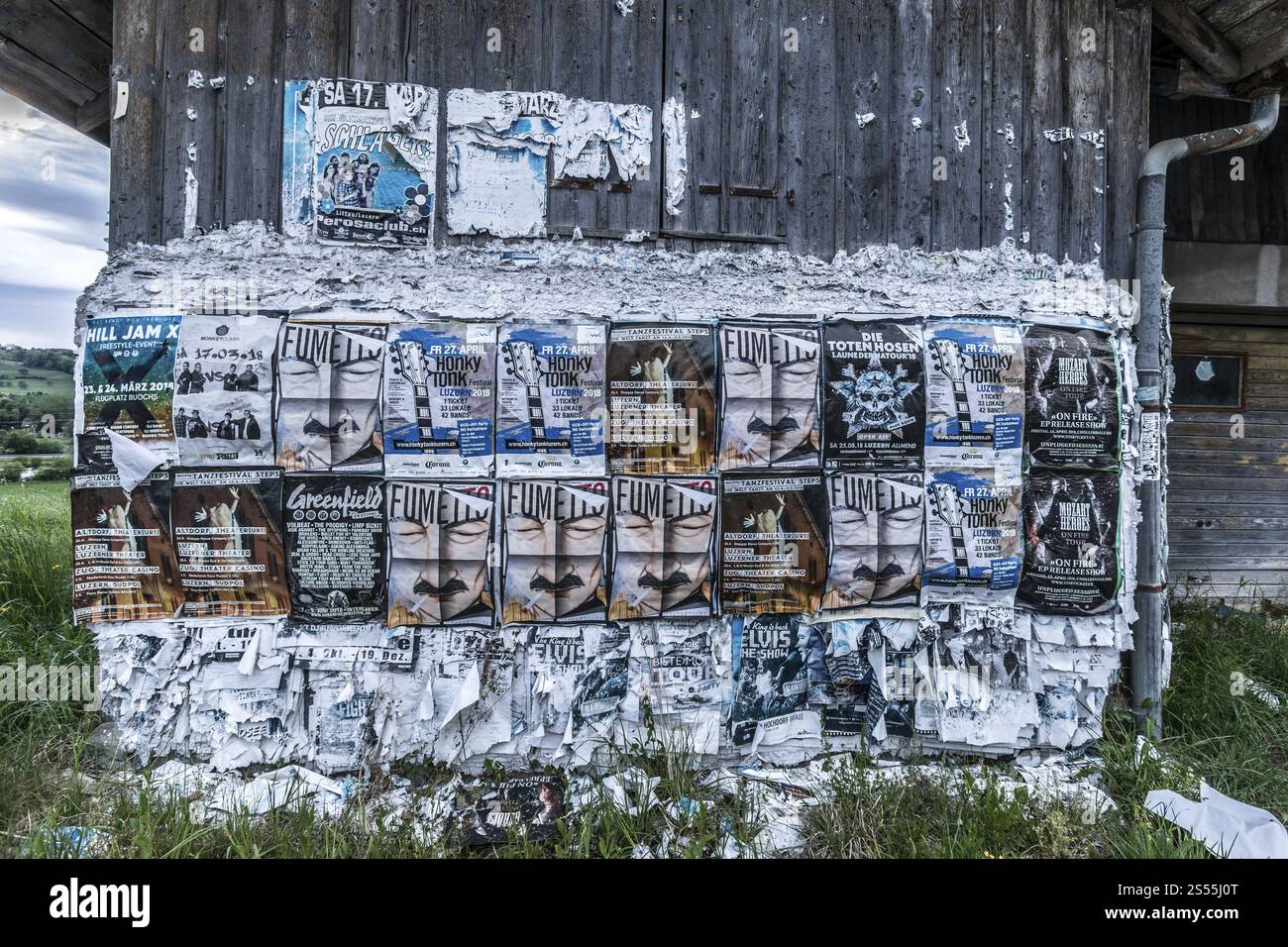Wooden wall of the outbuilding that was pasted over with event posters ...