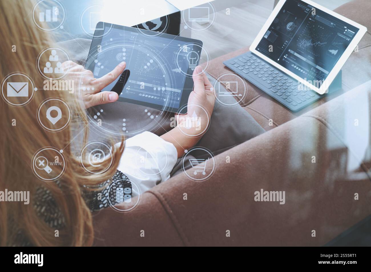 brunette woman using digital talet and laptop computer on sofa in ...