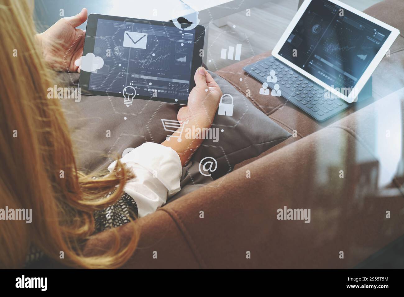 brunette woman using digital talet and laptop computer on sofa in ...