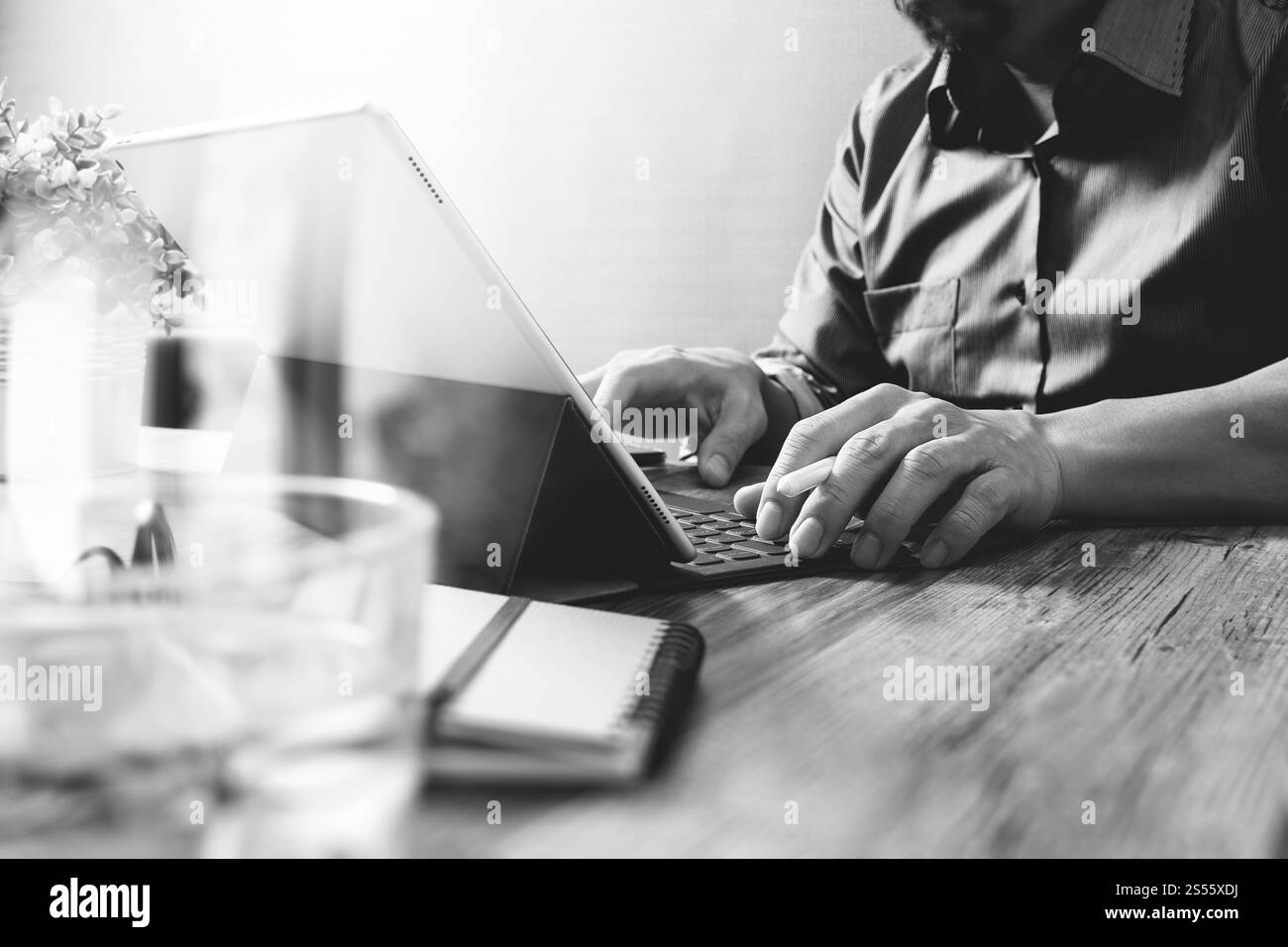 success businessman hand using stylus pen,digital tablet docking smart keyboard on wooden desk ...