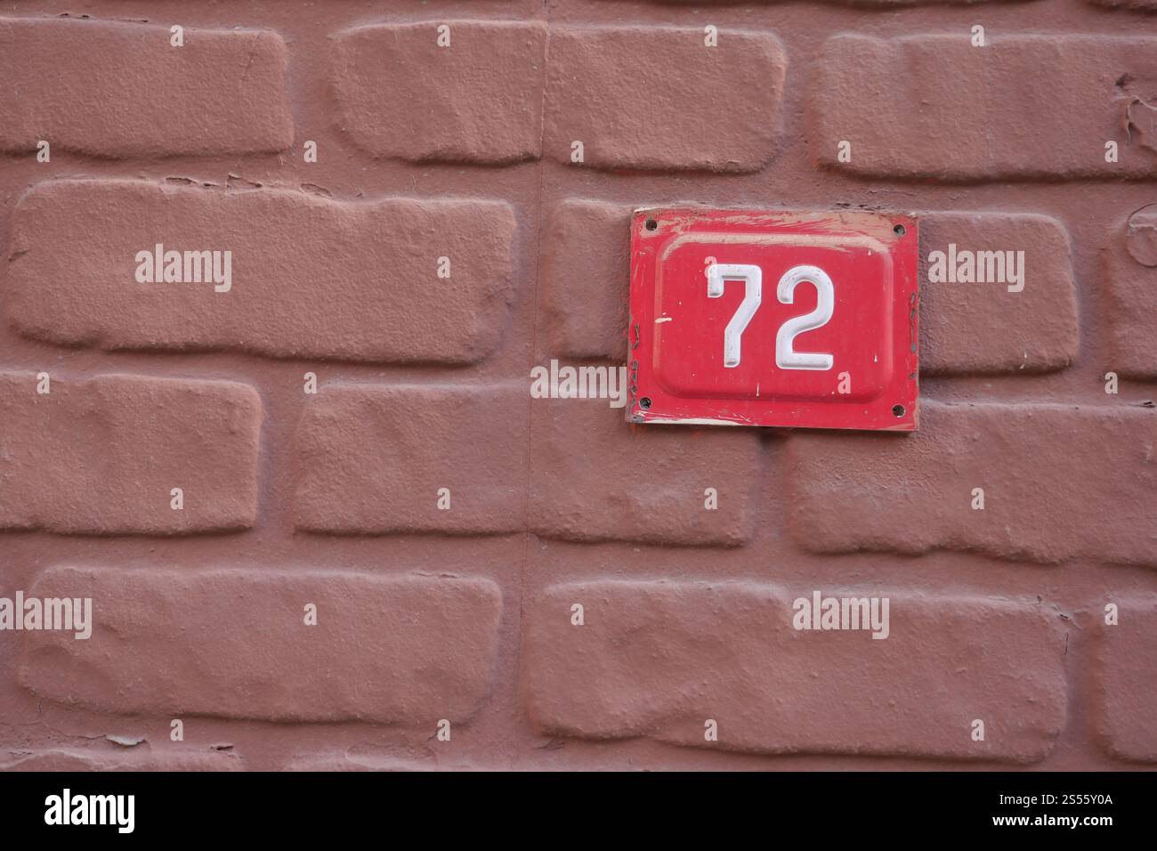 The number 72 stands out on a Red Tile against a Brown Brick Wall Stock ...
