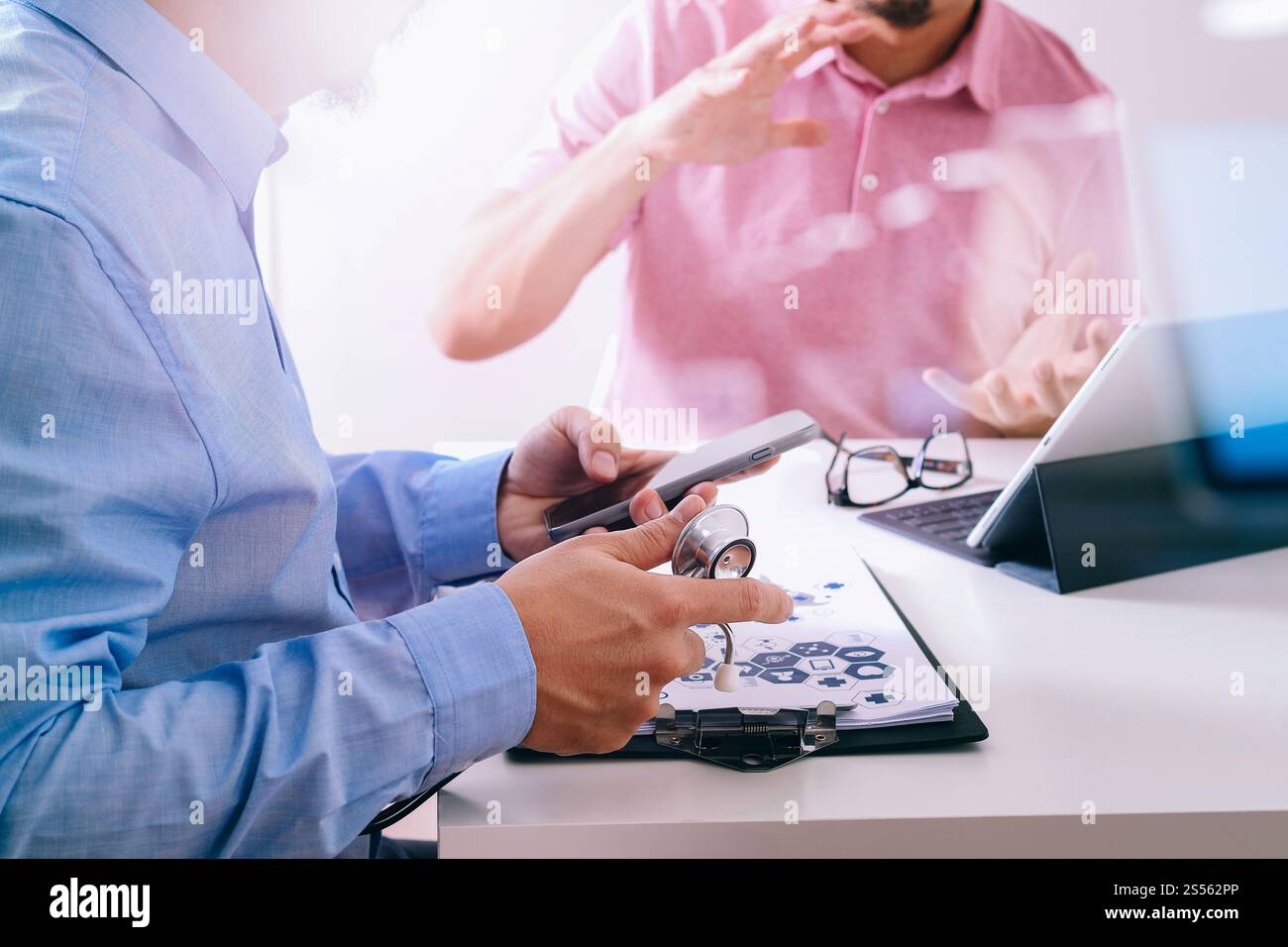 Medical doctor using mobile phone and consulting businessman patient ...