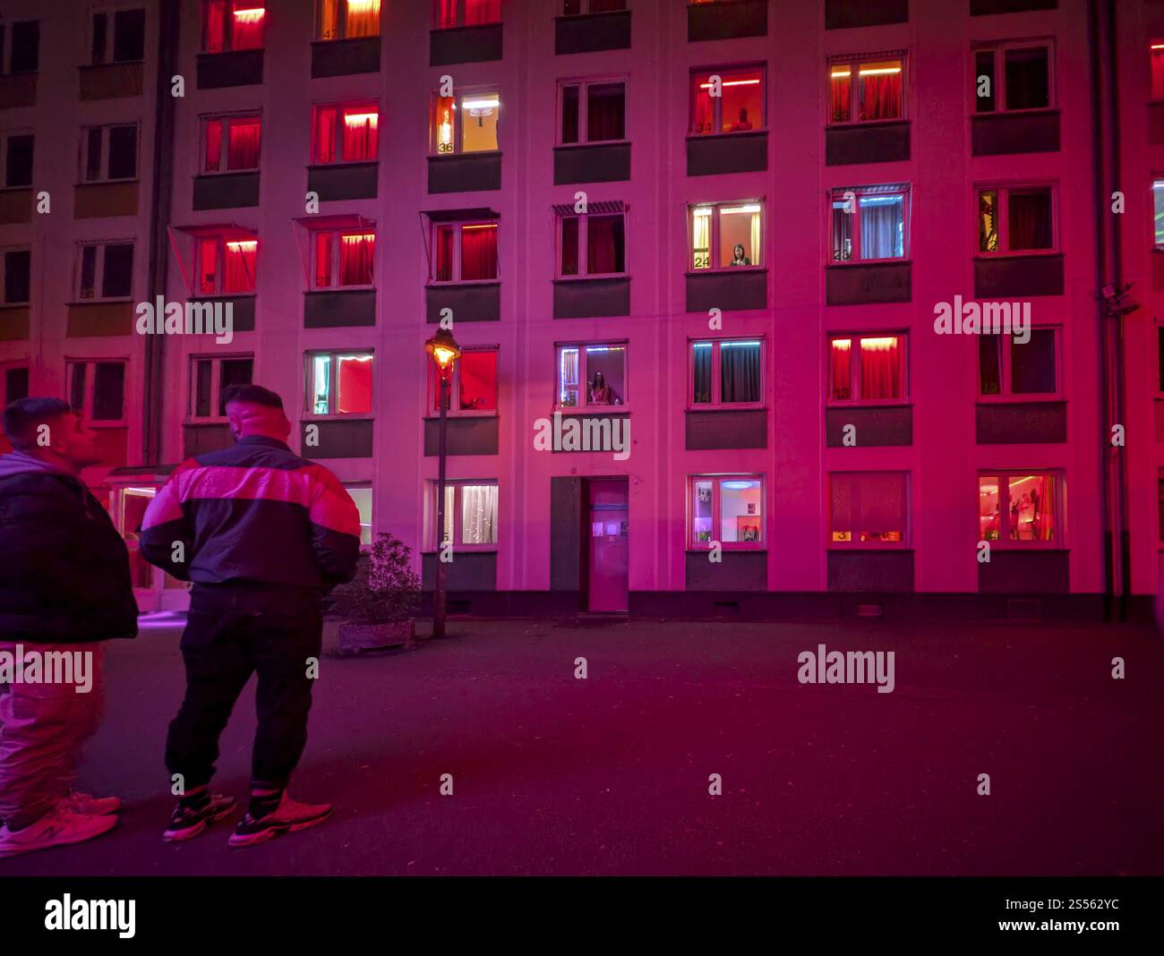 Laufhaus, clients in front of the facade of a red-lit brothel with ...
