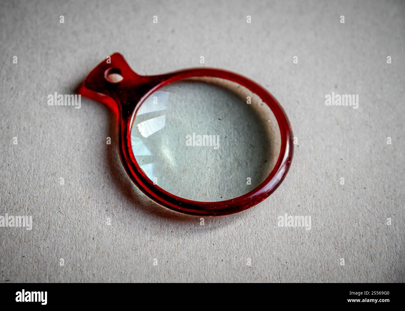 Magnifying glass closeup view on a paper background. Magnifying glass ...