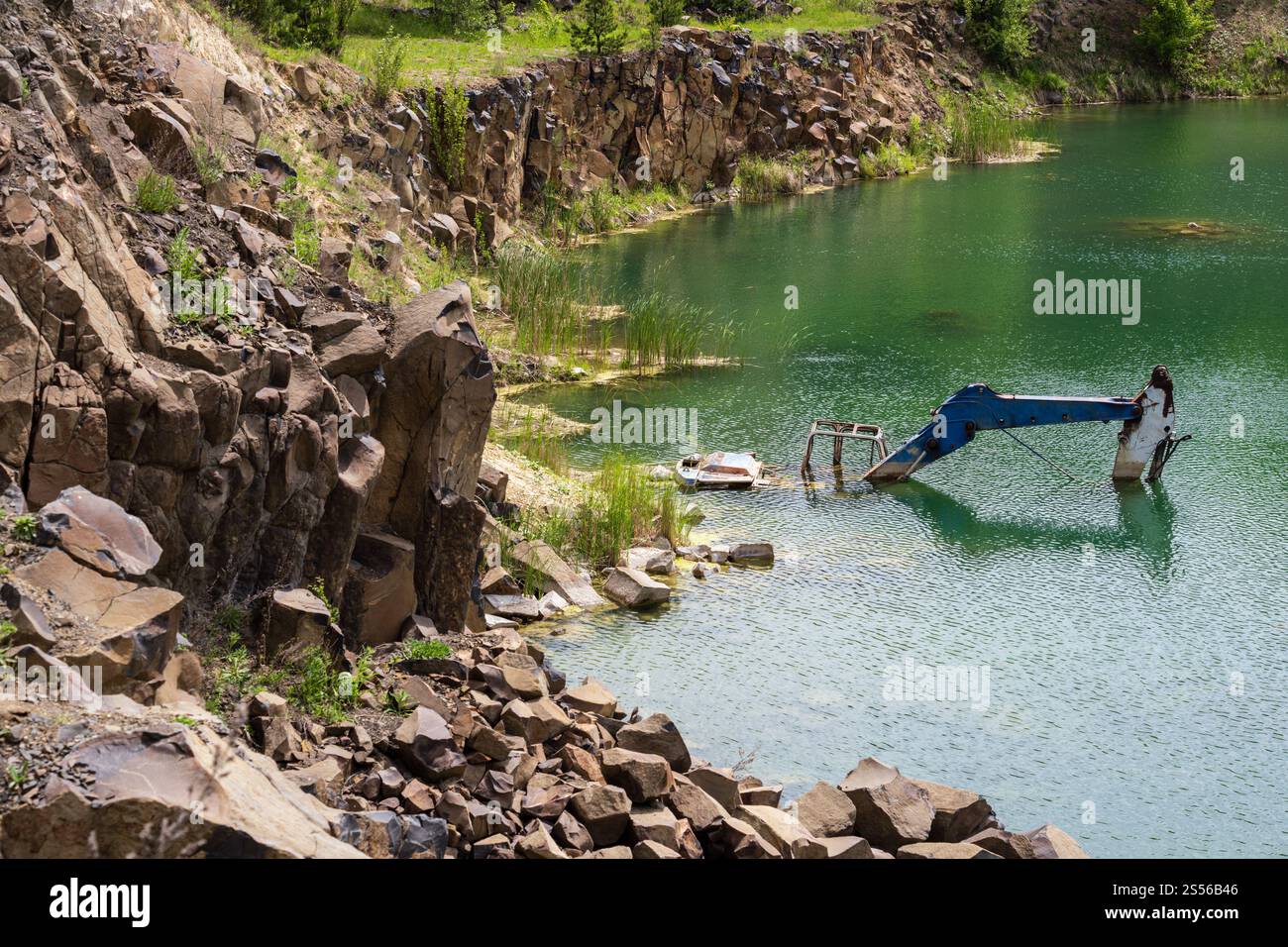 Drowned in flooded basalt quarry excavator. Summer Basalt Pillars ...