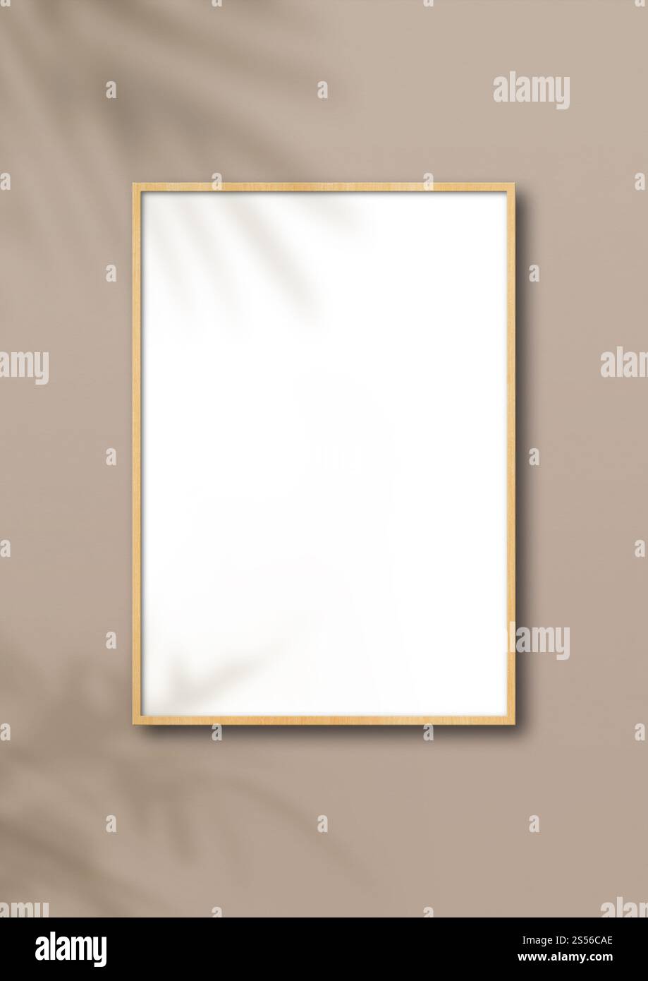 Vertical wooden picture frame hanging on a light beige wall. Floral ...