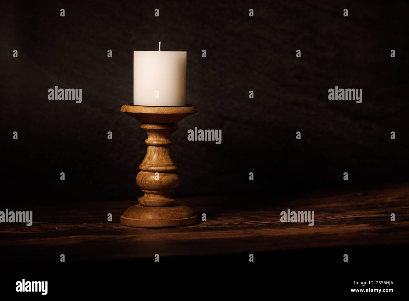 Single white candle on a wooden candlestick. Candle is not lit Stock ...