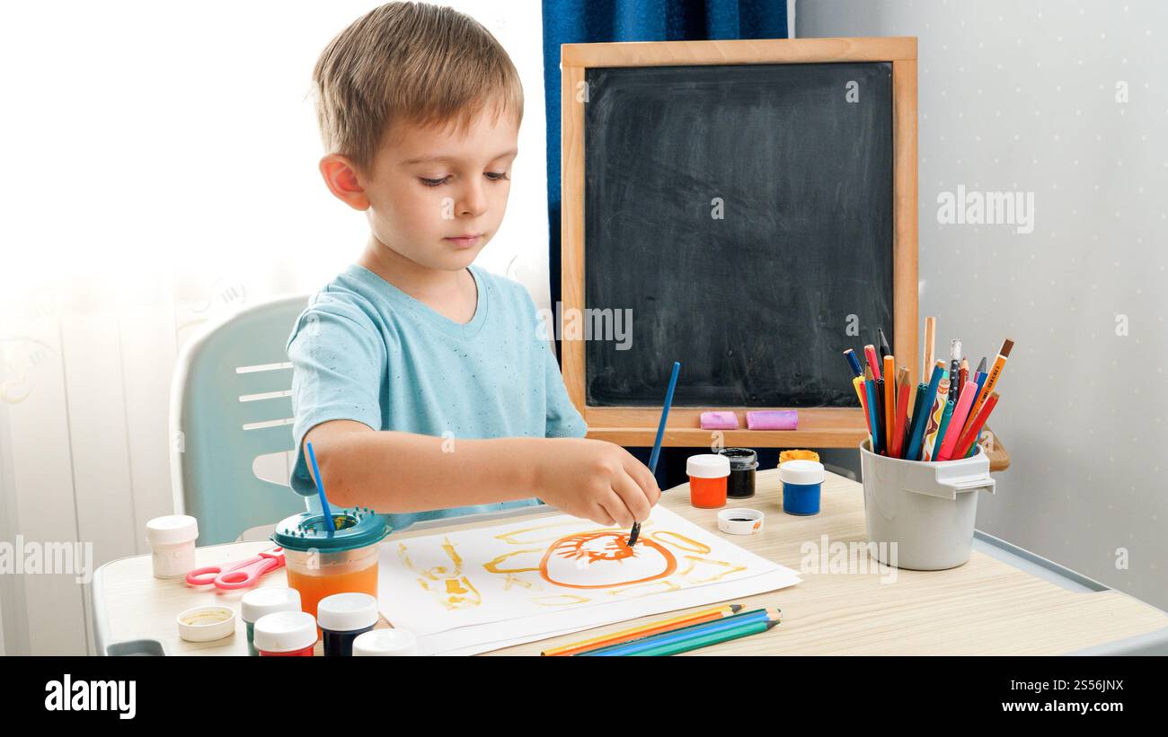 Little boy drawing picture in school classroom. Creative child doing ...