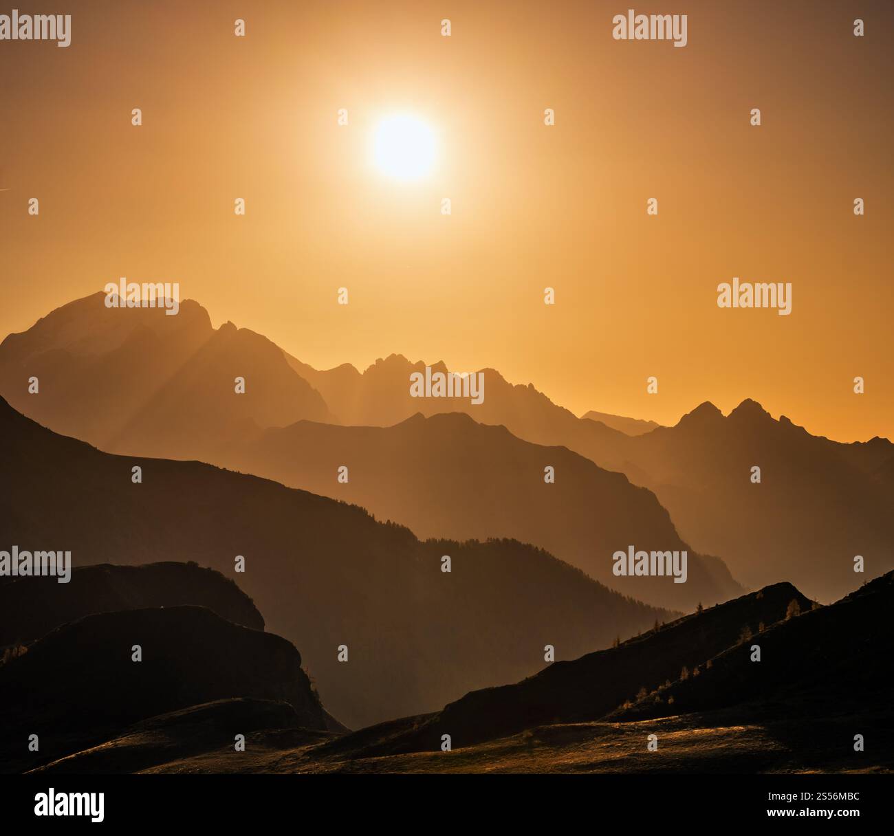 Sun glow in evening hazy sky and mountain silhouettes view. Peaceful ...