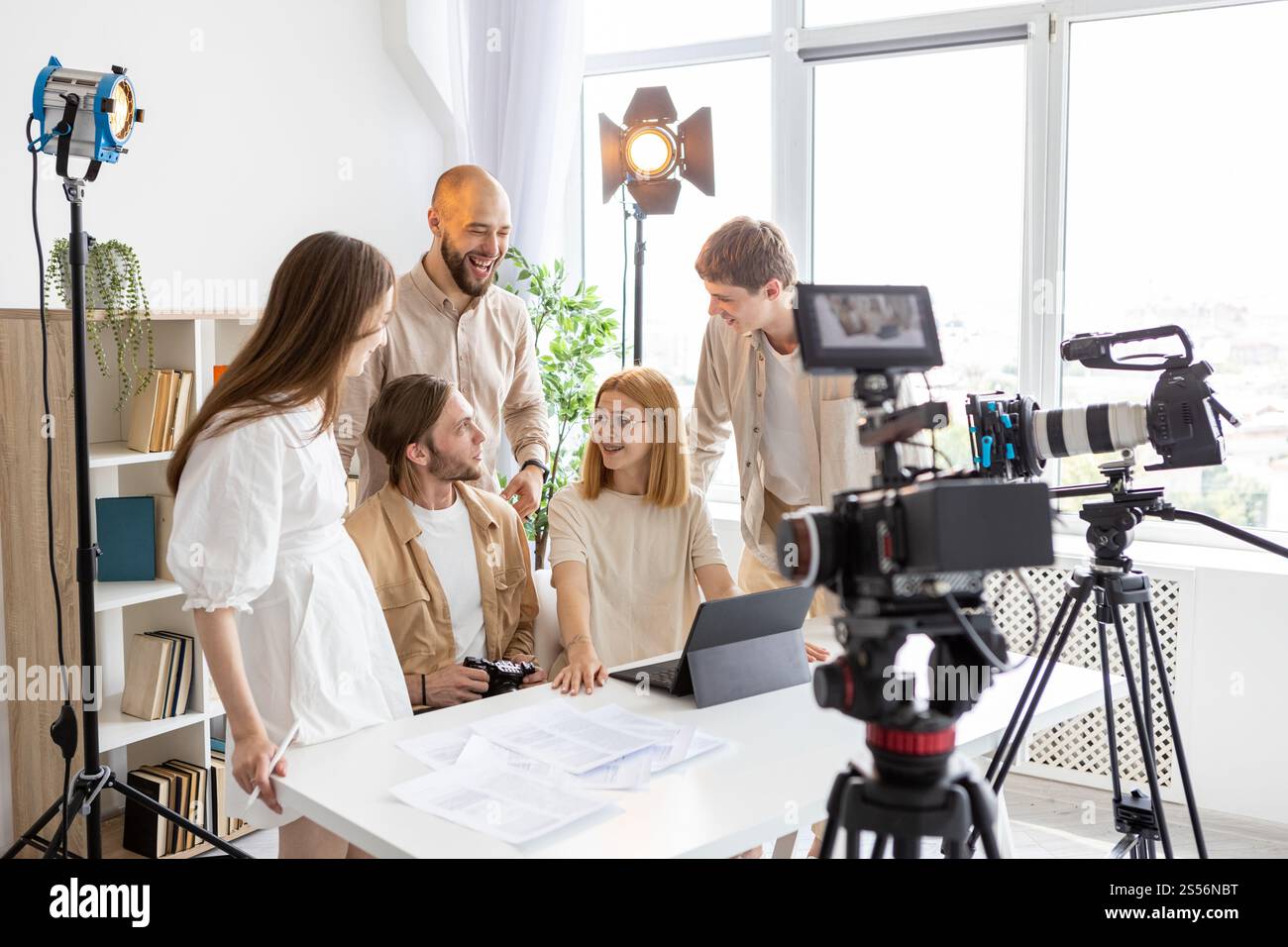 Coworkers cooperation. Happy team. Smiling colleagues work paper documents front of video ...