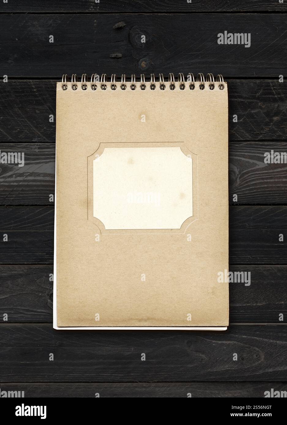Closed spiral Note book with empty label on a black wood table. Mockup ...