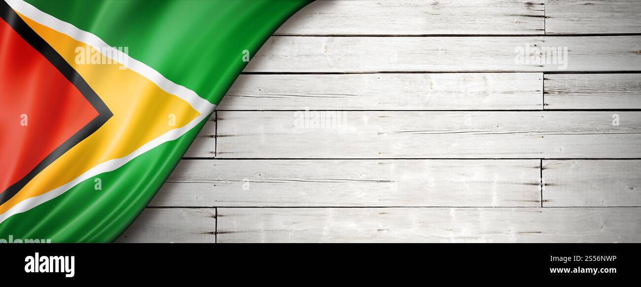 Guyana flag on concrete wall. Horizontal panoramic banner. Guyanese flag on old white wall ...