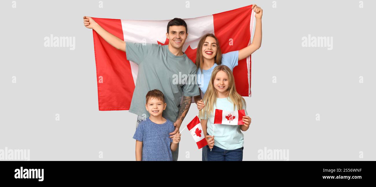 Happy family with flags of Canada on light background Stock Photo - Alamy