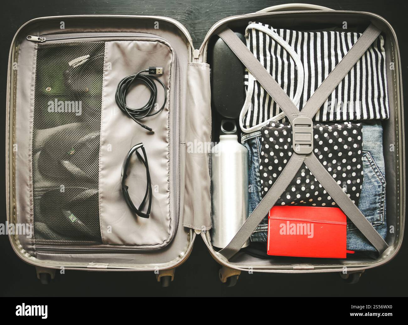 Open travel suitcase full of clothes isolated on black background. Open ...