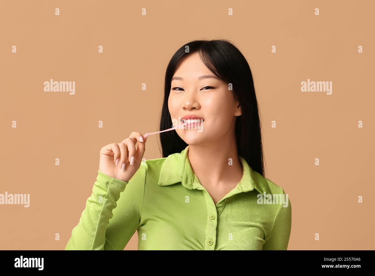 Pretty young Asian woman pulling chewing gum on beige background Stock ...