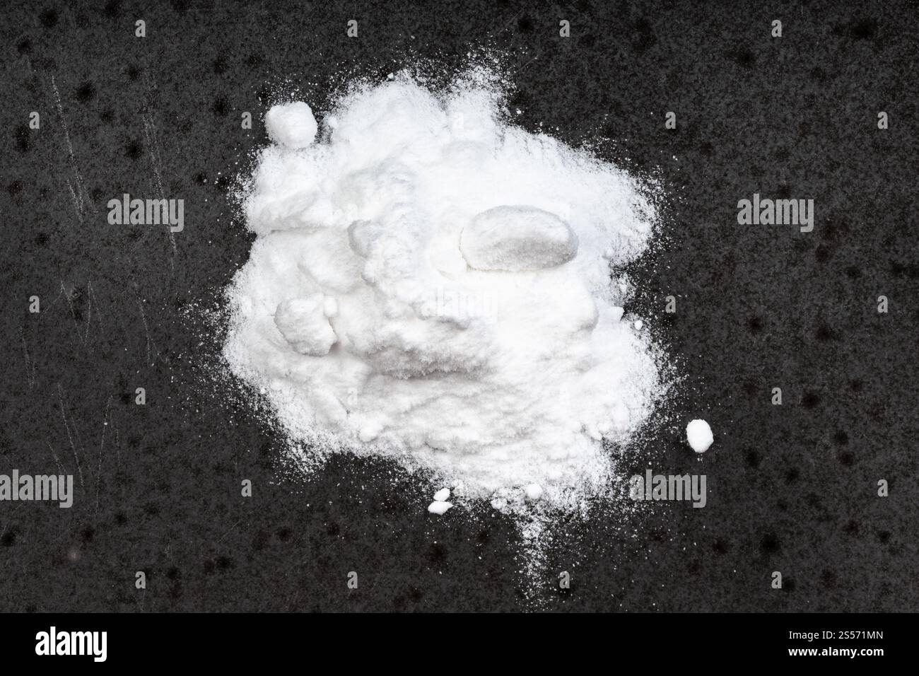 top view of pile of sodium bicarbonate close up on black ceramic plate ...