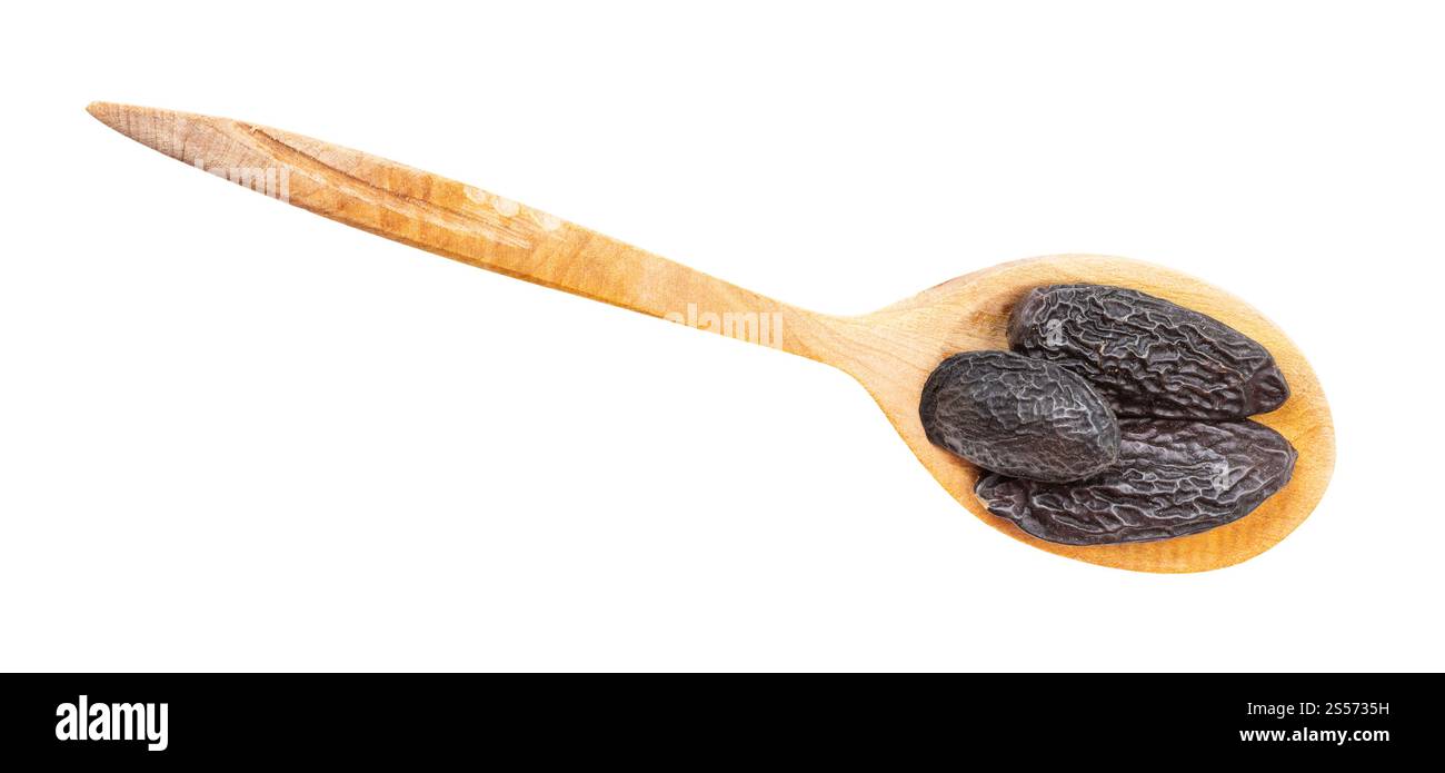 top view of dried tonka beans in wood spoon isolated on white ...