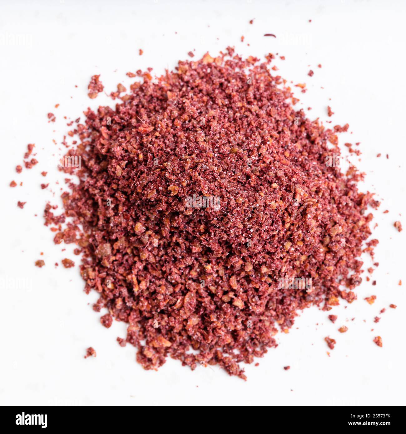 top view of pile of ground sumac spice close up on gray ceramic plate ...