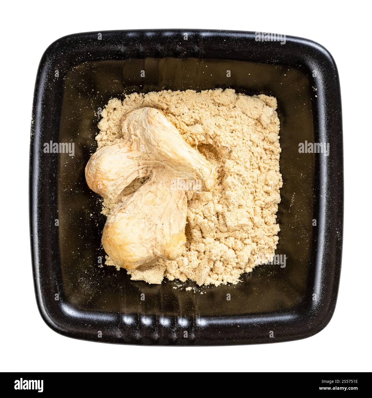 top view of dried ginger root and powder in black bowl isolated on ...