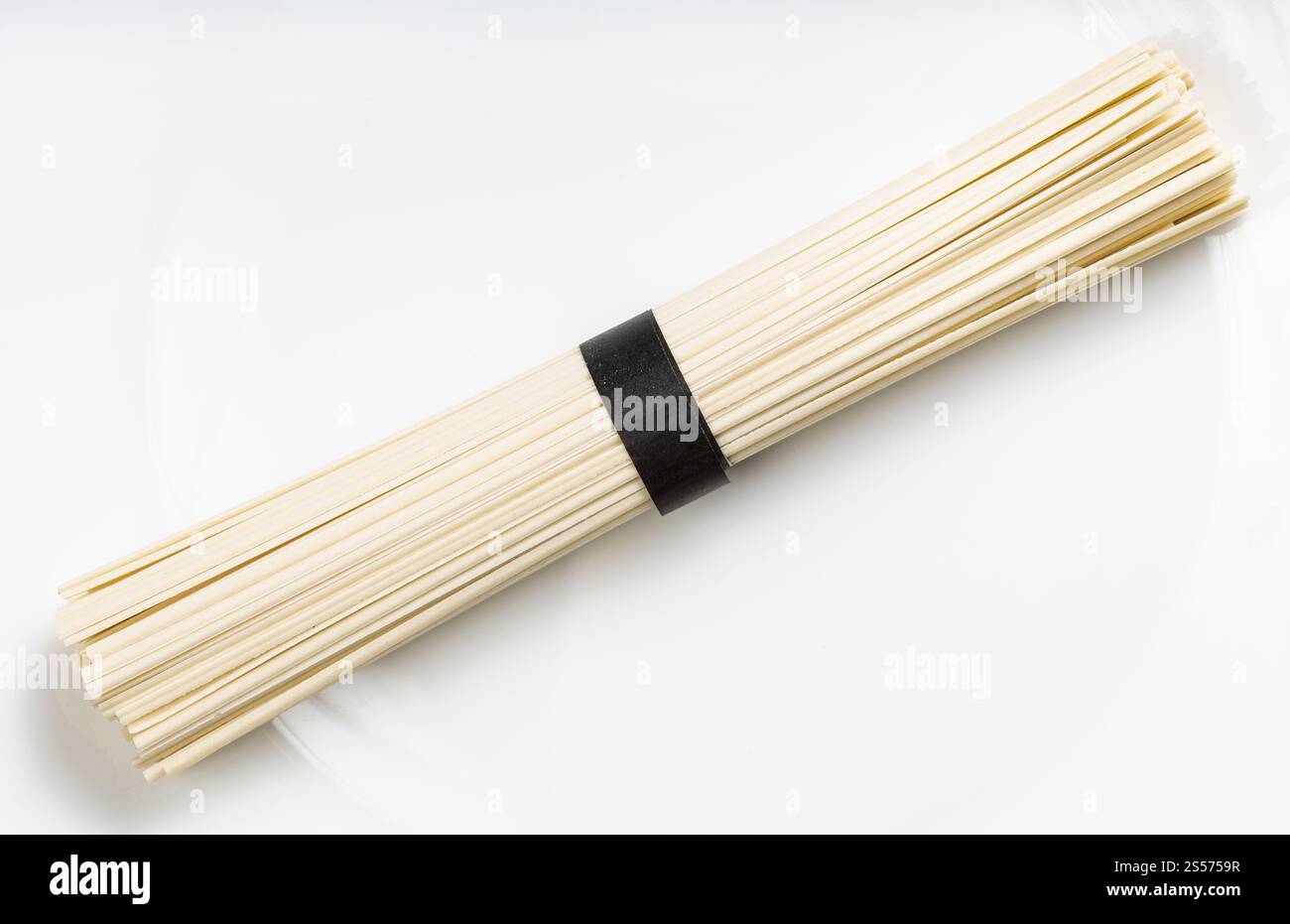 bunch of dried round Udon noodles from wheat flour on white plate Stock ...