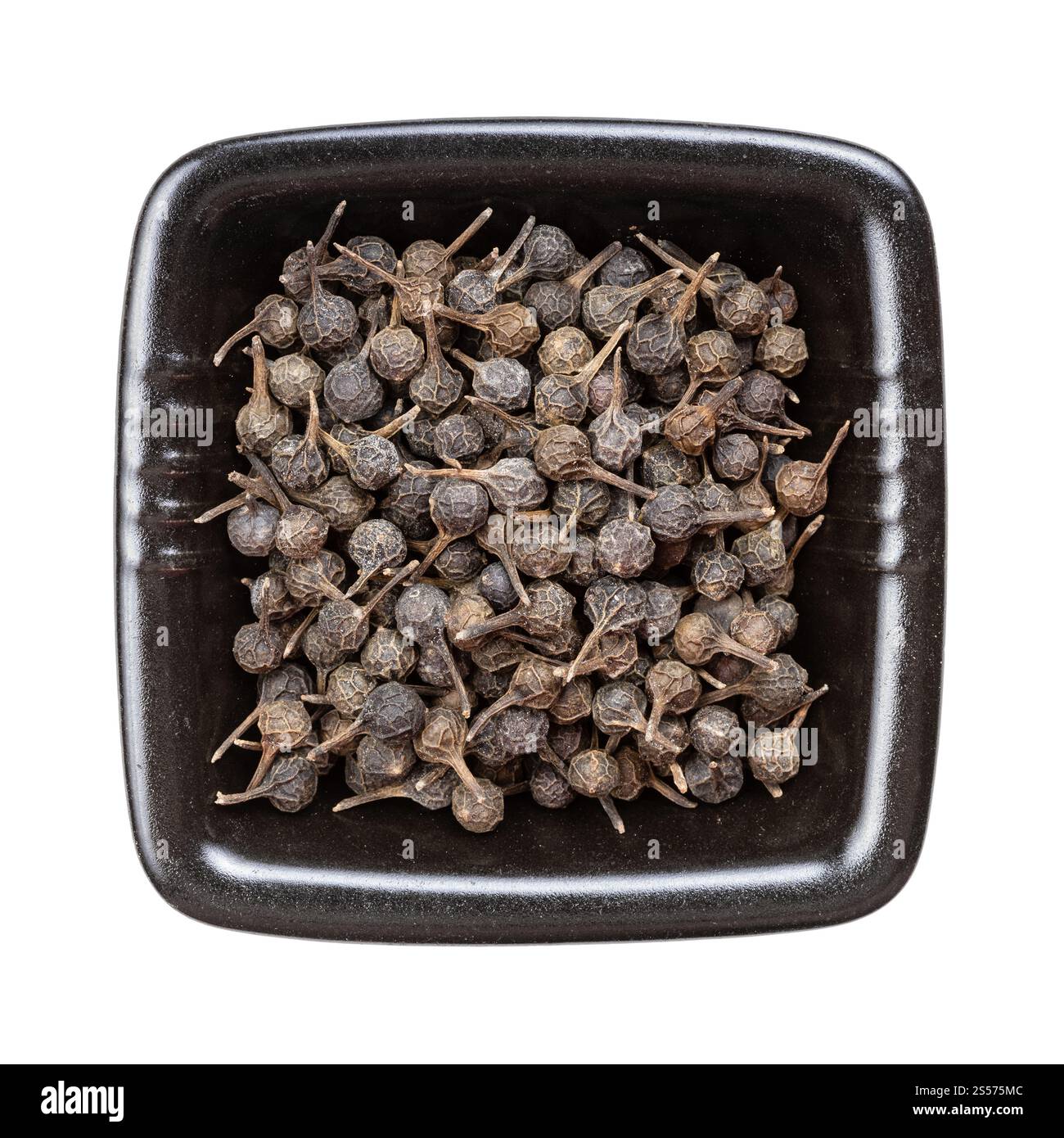top view of tailed pepper (cubeb) in black bowl isolated on white ...