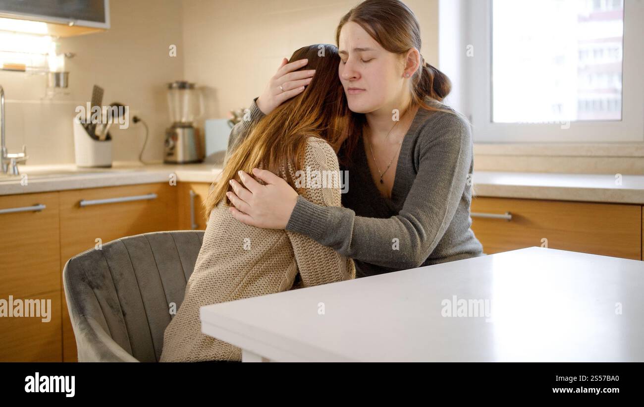 Teenage girl complaining and telling mother about problems on kitchen ...