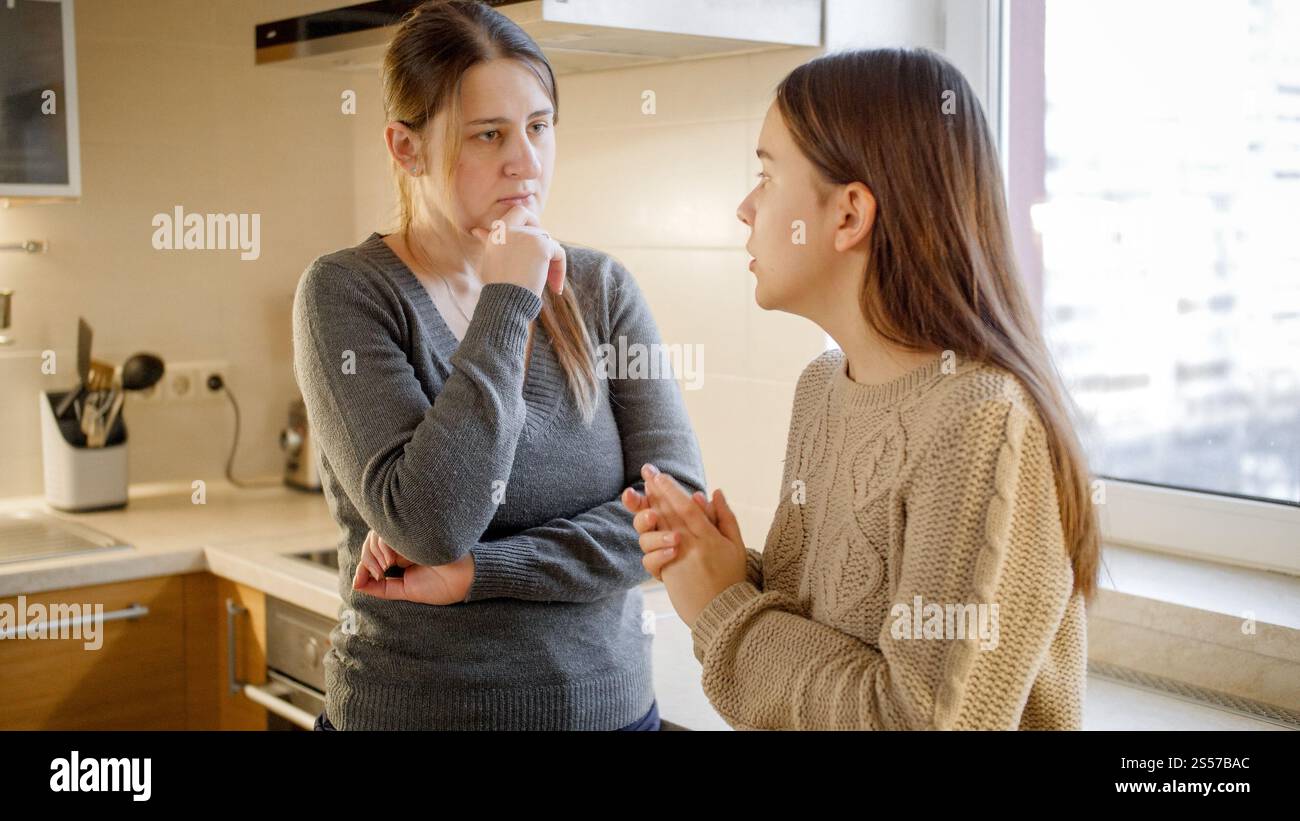 Young mother listening and talking to her teenage daughter complaining ...