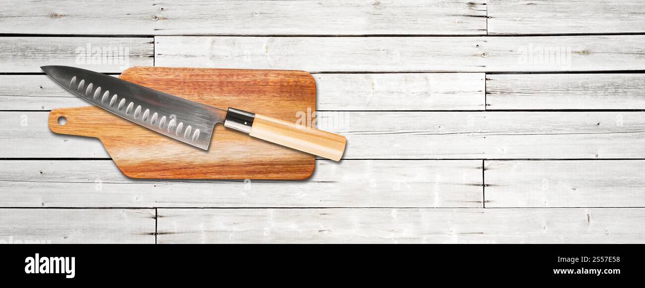 Traditional Japanese gyuto chief knife on a cutting board. White wooden ...