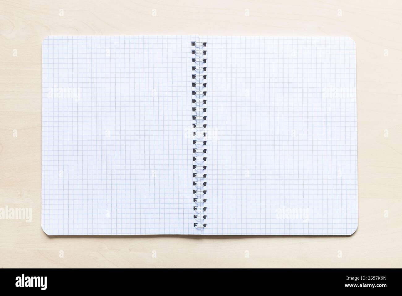 top view of open blank spiral notebook with squared pages on light ...