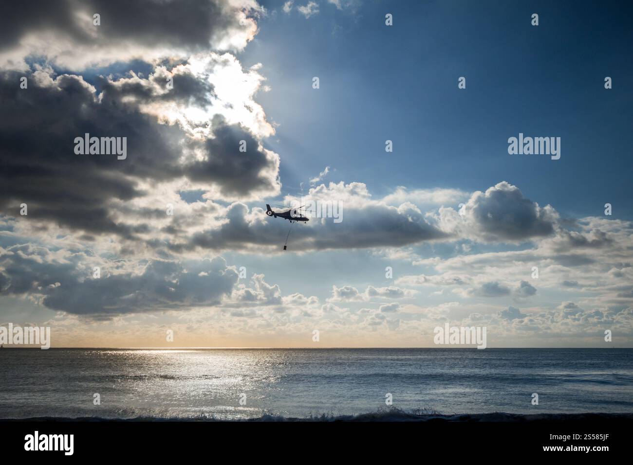 helicopter flying on a cloudy seascape view from a beach. helicopter on ...