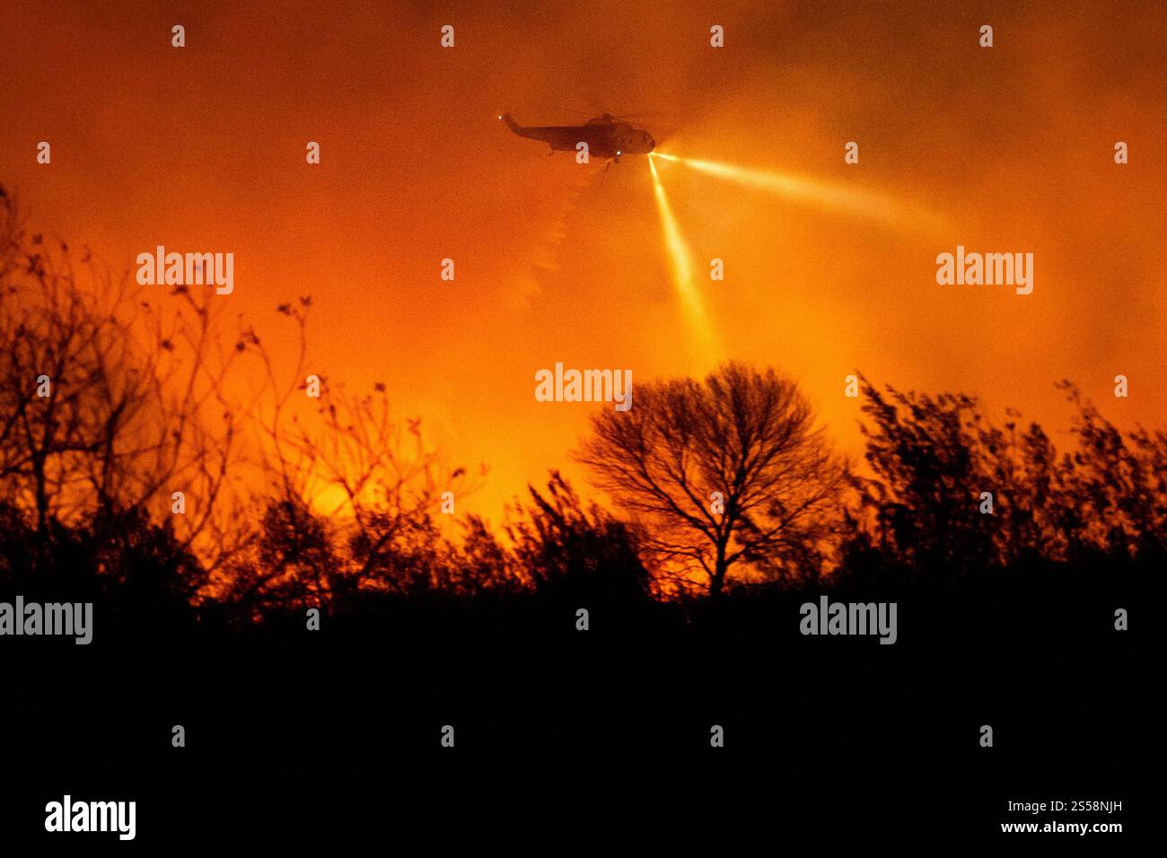 A helicopter drops water while fighting the Auto Fire in Ventura County ...