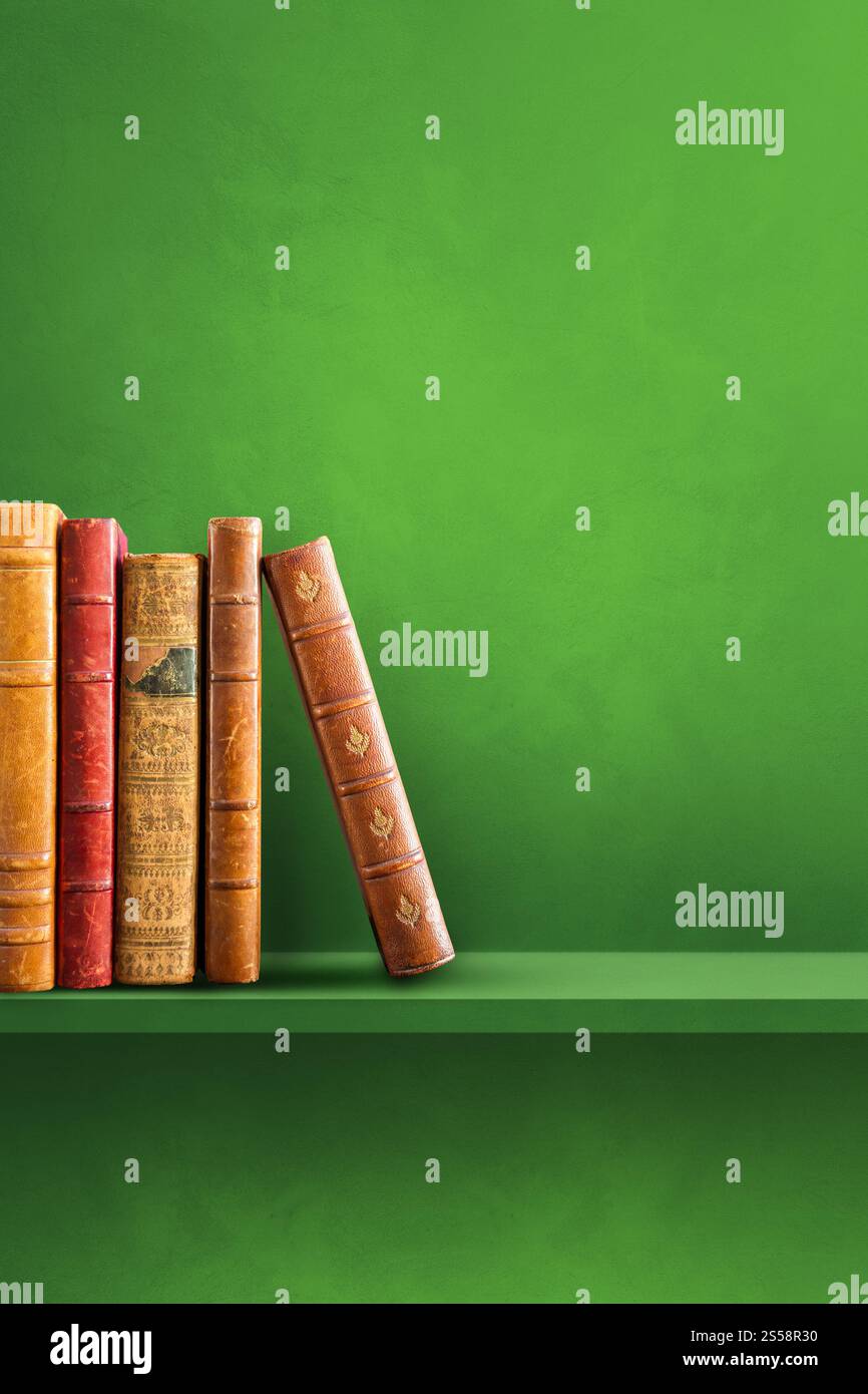 Row of old books on green shelf. Vertical background scene. Row of old ...