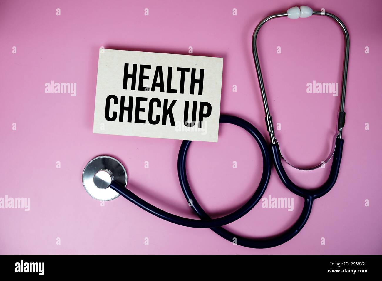 Health Check up text with stethoscope top view on pink background ...