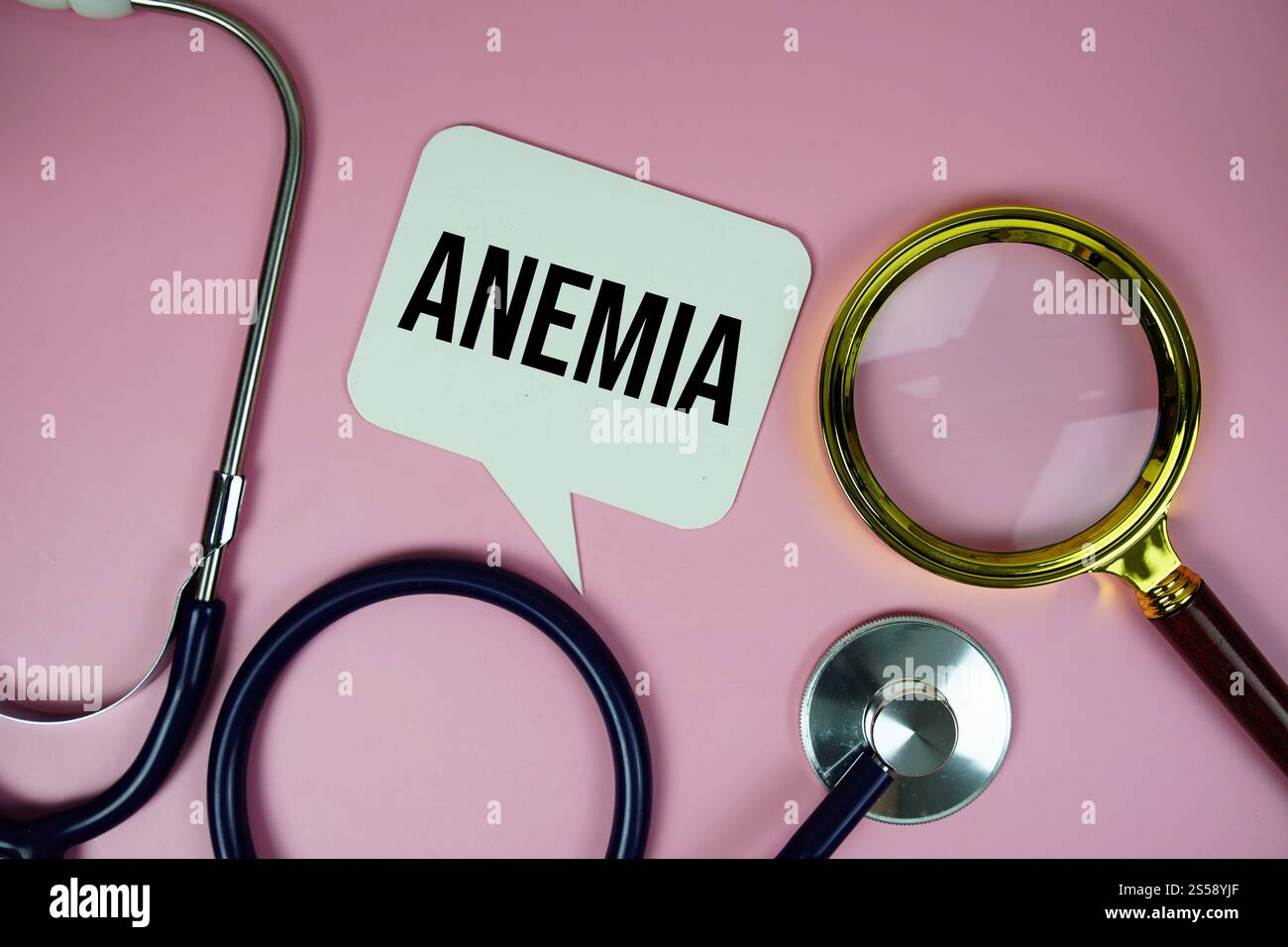 Anemia text with stethoscope and magnifying glass on pink background ...