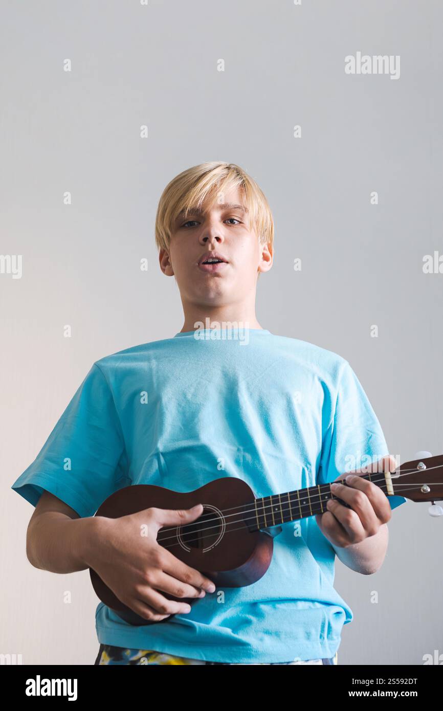 Teen boy exercising playing ukulele, at home Stock Photo - Alamy
