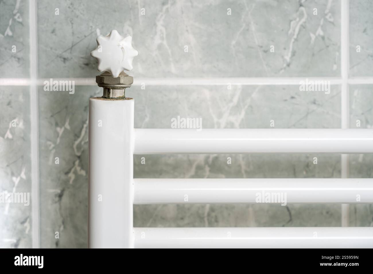White radiator hung on the wall in a bathroom with green ceramic tiles ...