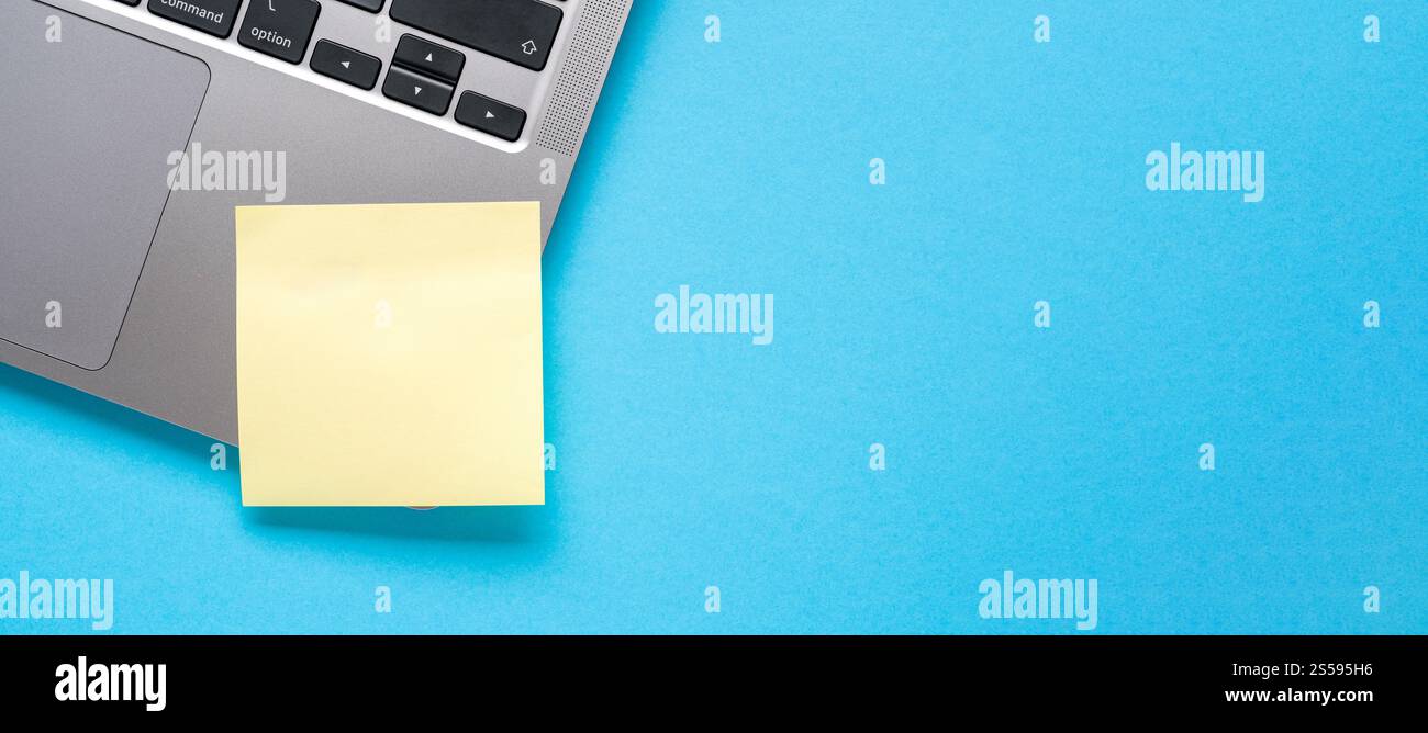 Note paper stuck to the corner of the laptop on the blue desk Stock ...