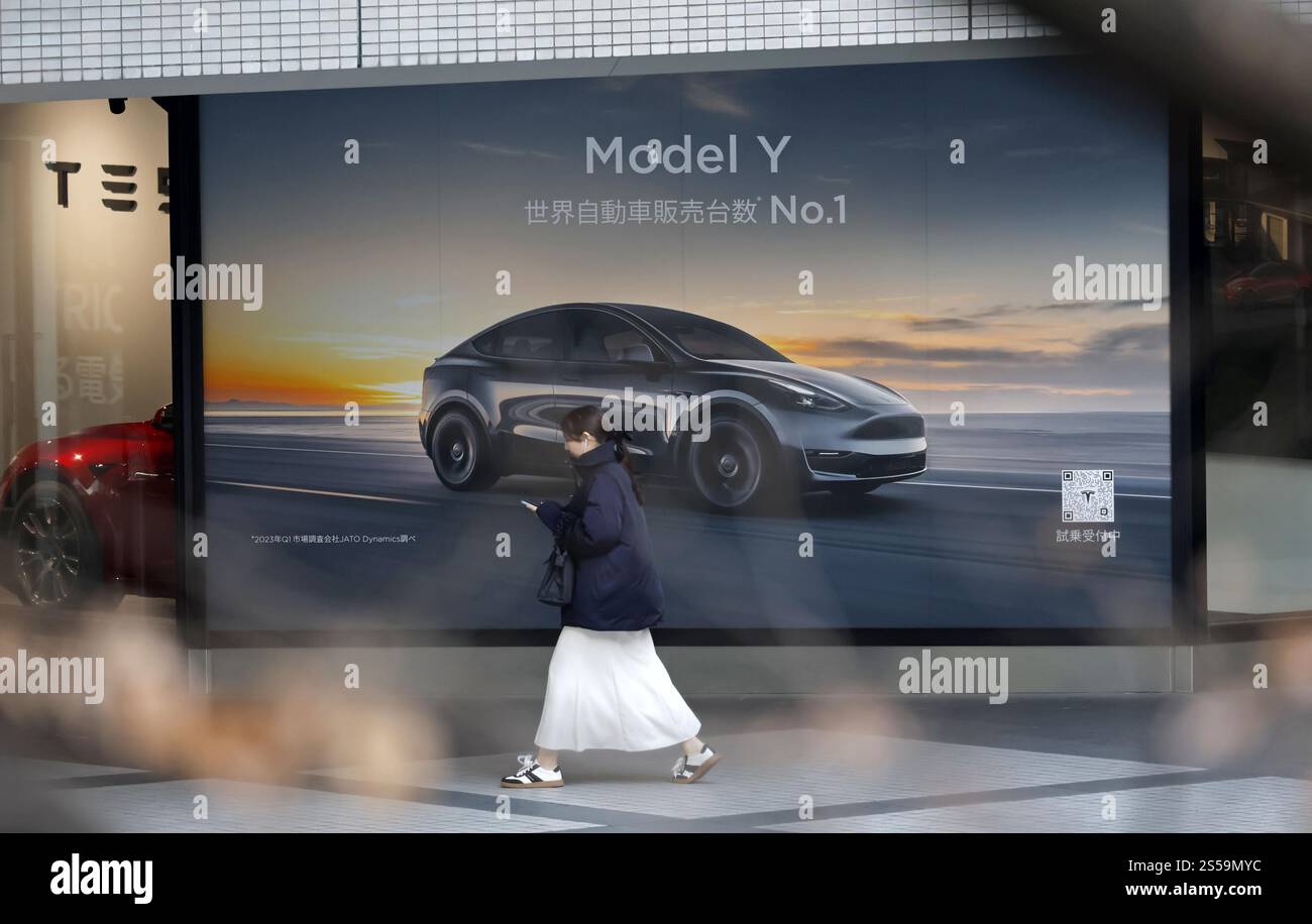 A pedestrian walks past an advertisement board for Tesla Inc. at a ...