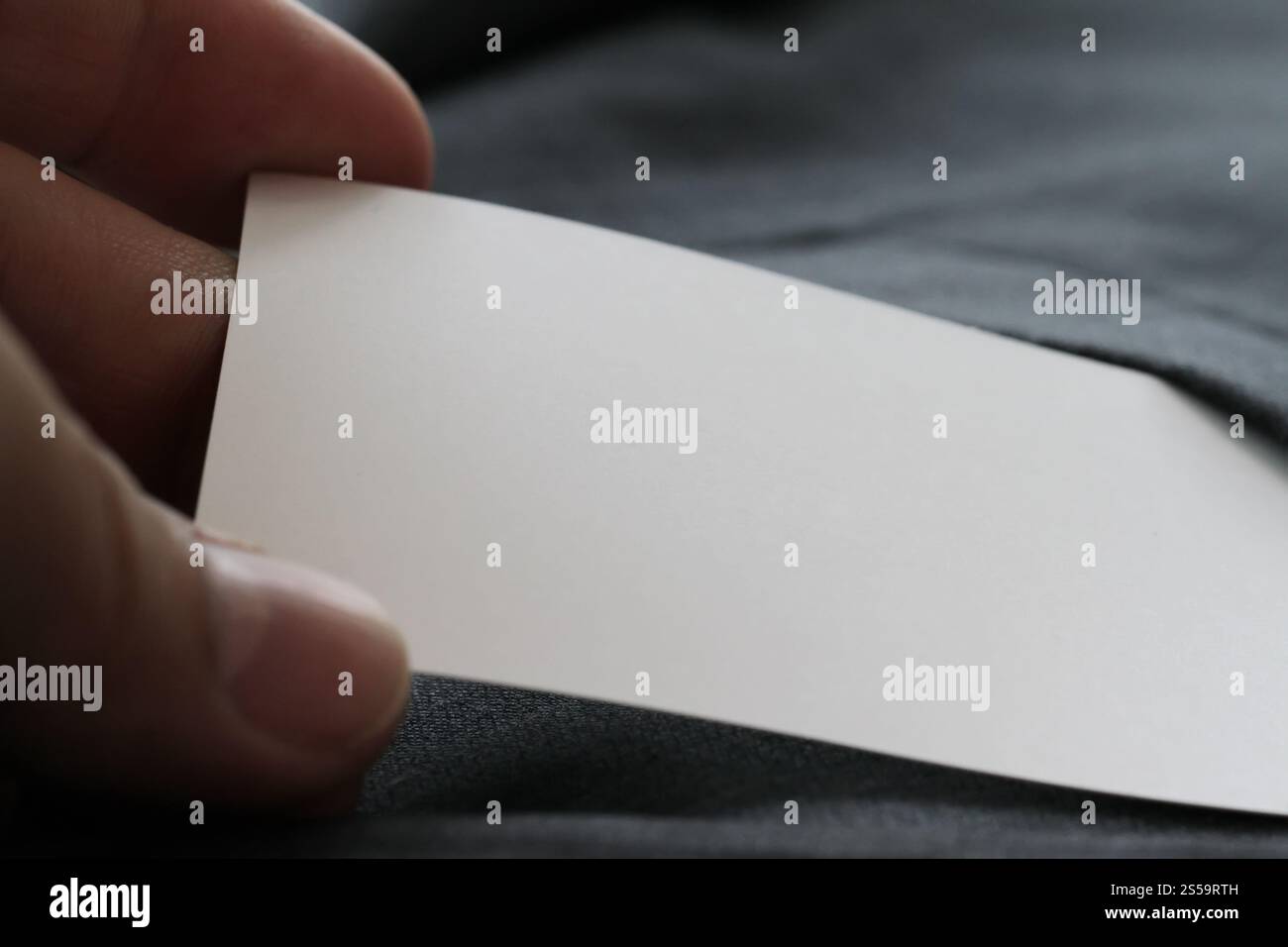 close up of hand picking blank business card from gray suit pocket ...