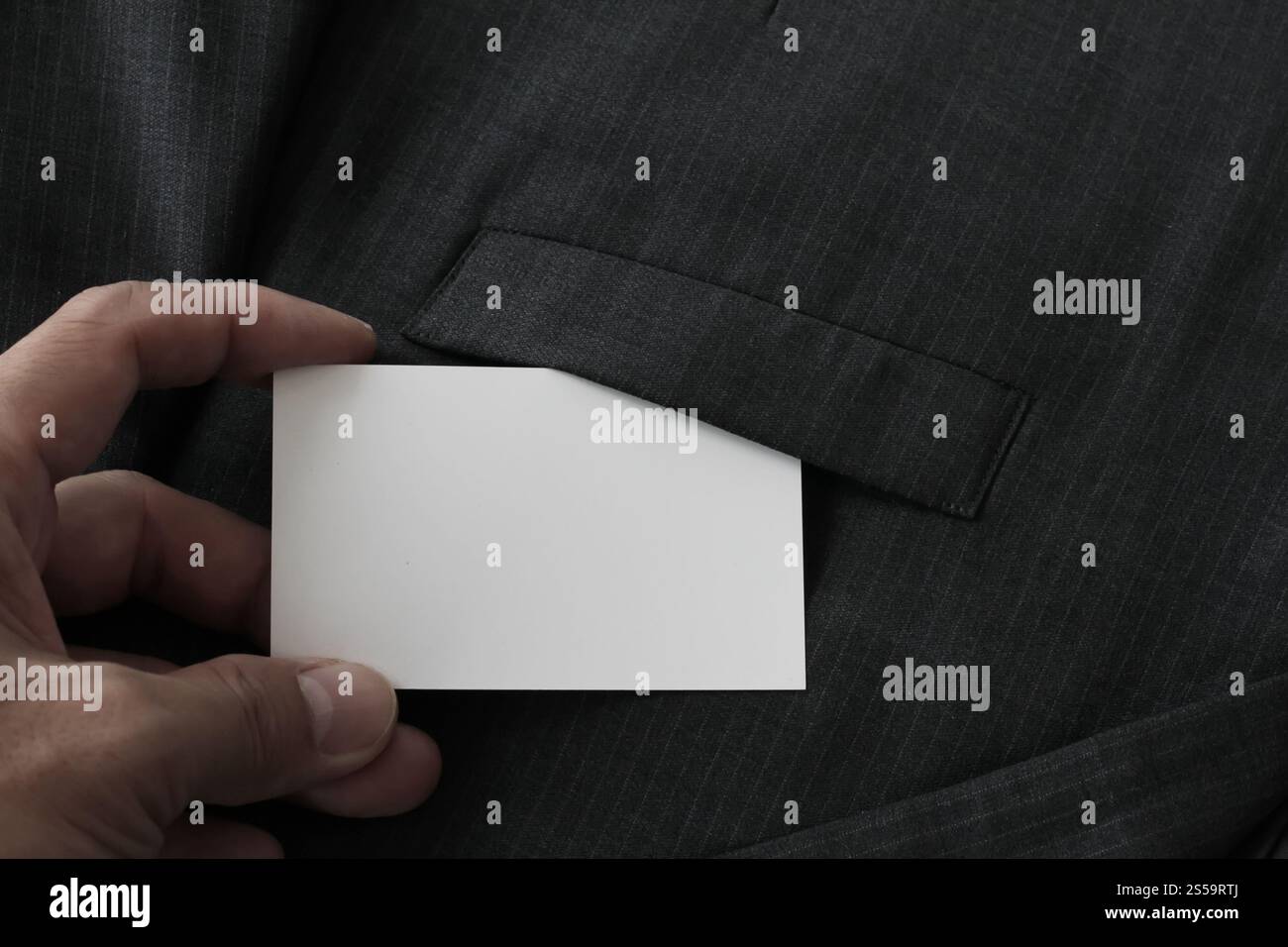 close up of hand picking blank business card from gray suit pocket ...