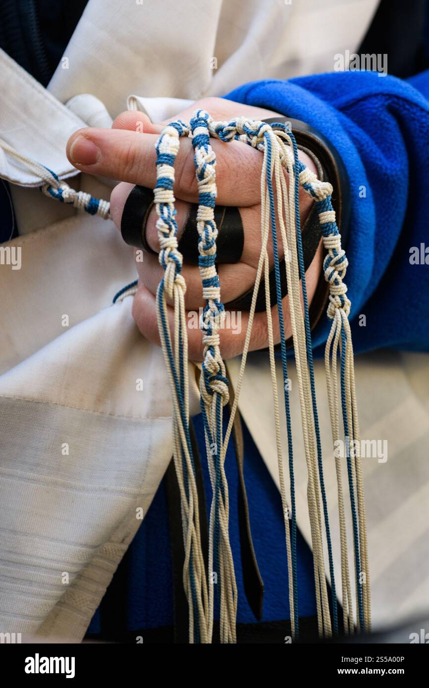 Closeup of the hand of an Orthodox, Jewish man holding blue techelet ...