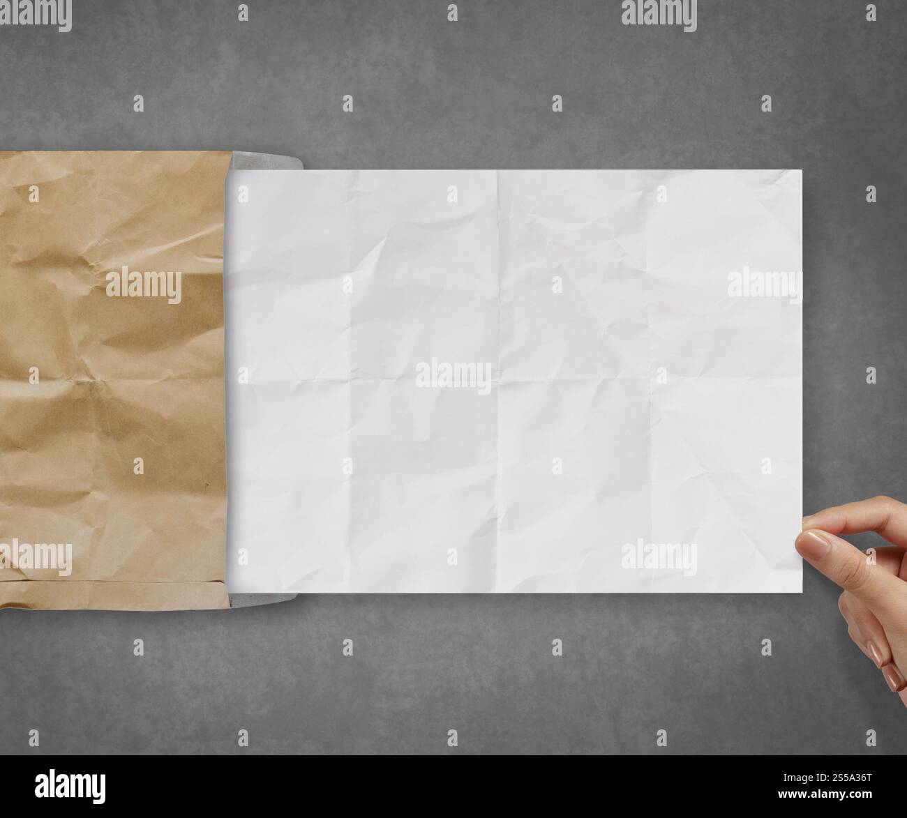 hand pulling crumpled paper from recycle envelope as concept background ...