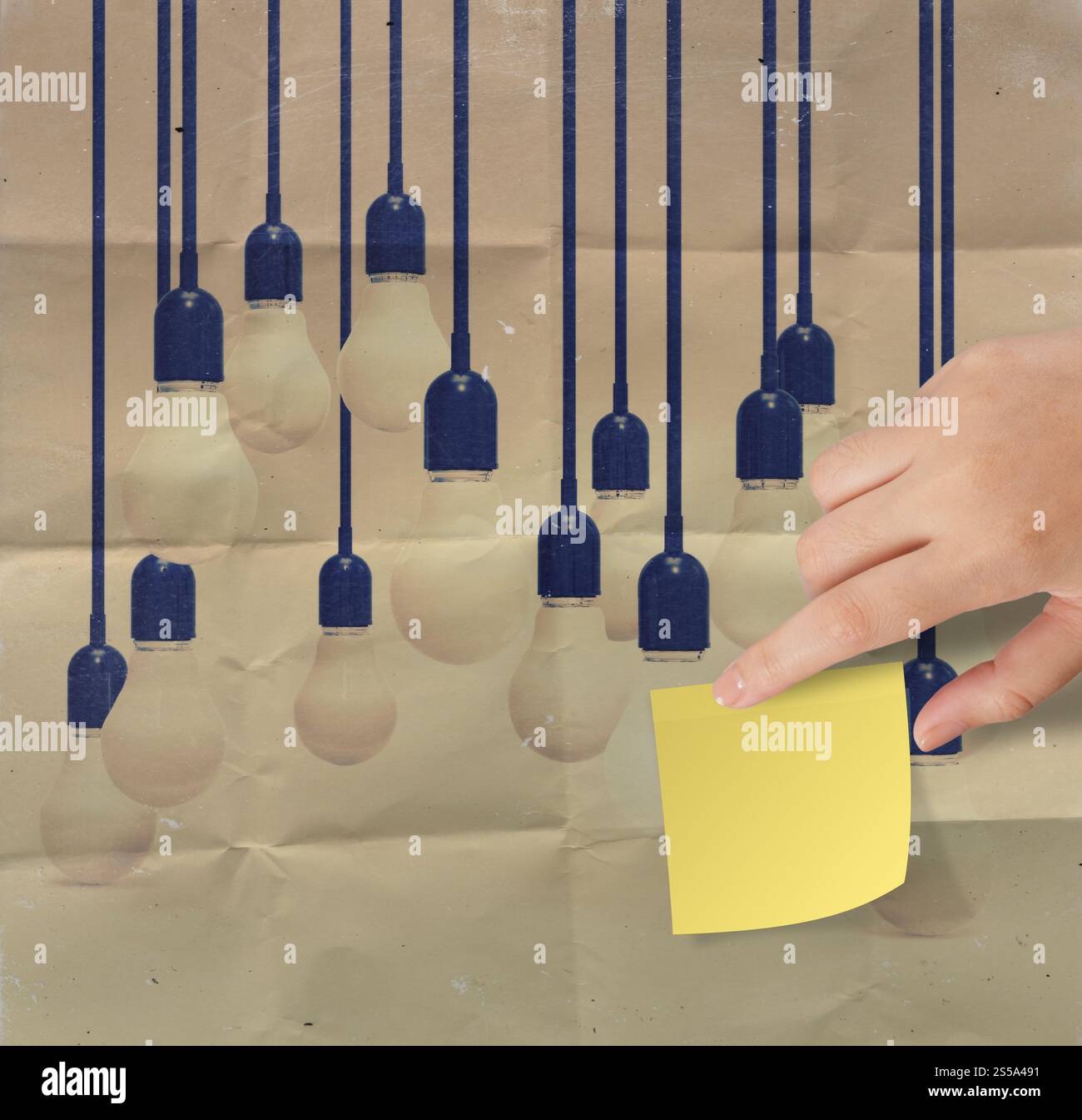 hand touch sticky note with another idea light bulb on crumpled paper ...