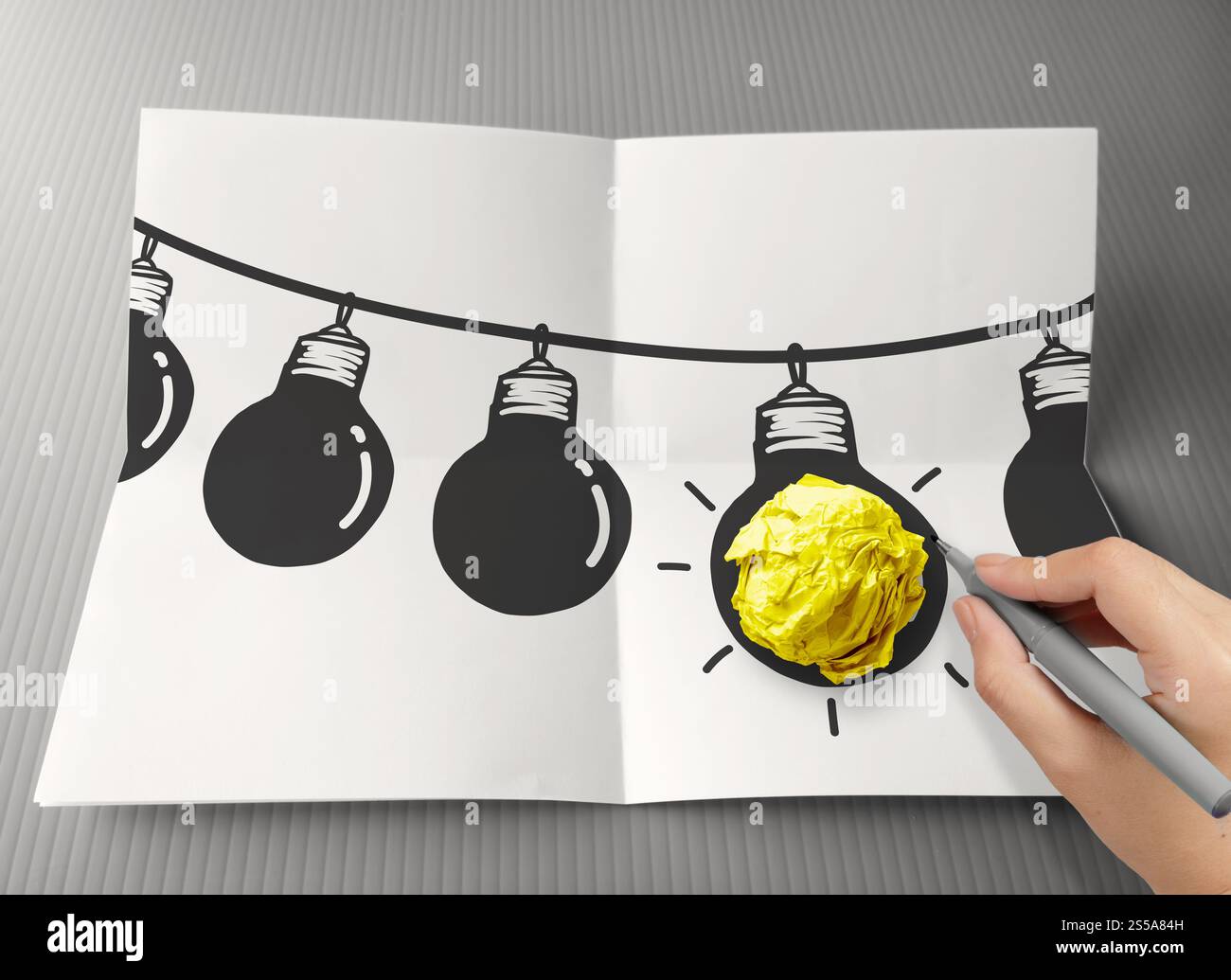 hand drawn light bulb on wire doodle with crumpled paper as leadership ...