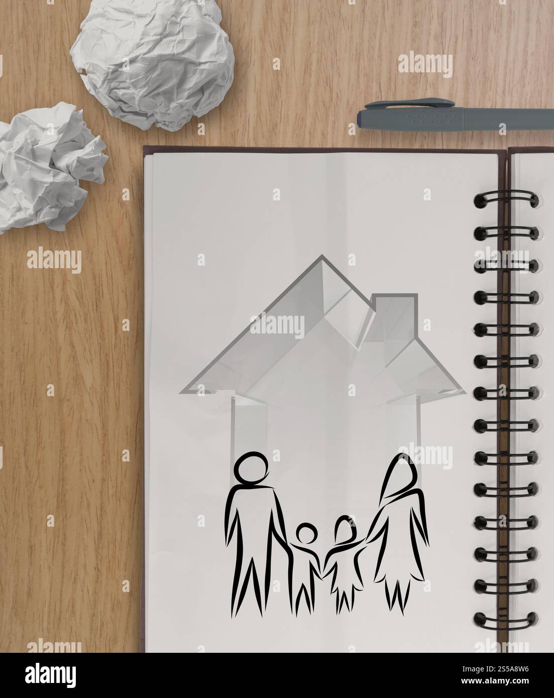 hand draw family and house icon on note book with wooden background as ...