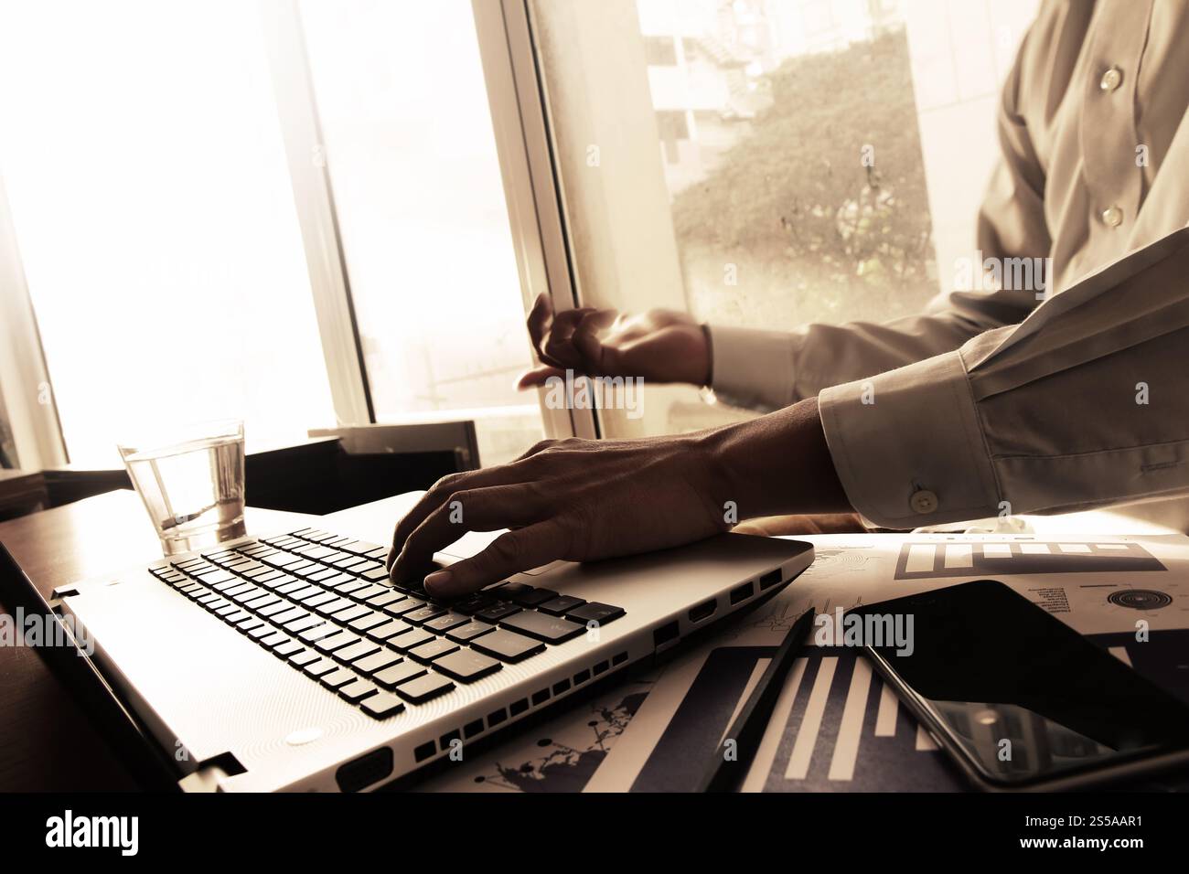 business man hand working on laptop computer on wooden desk as concept ...