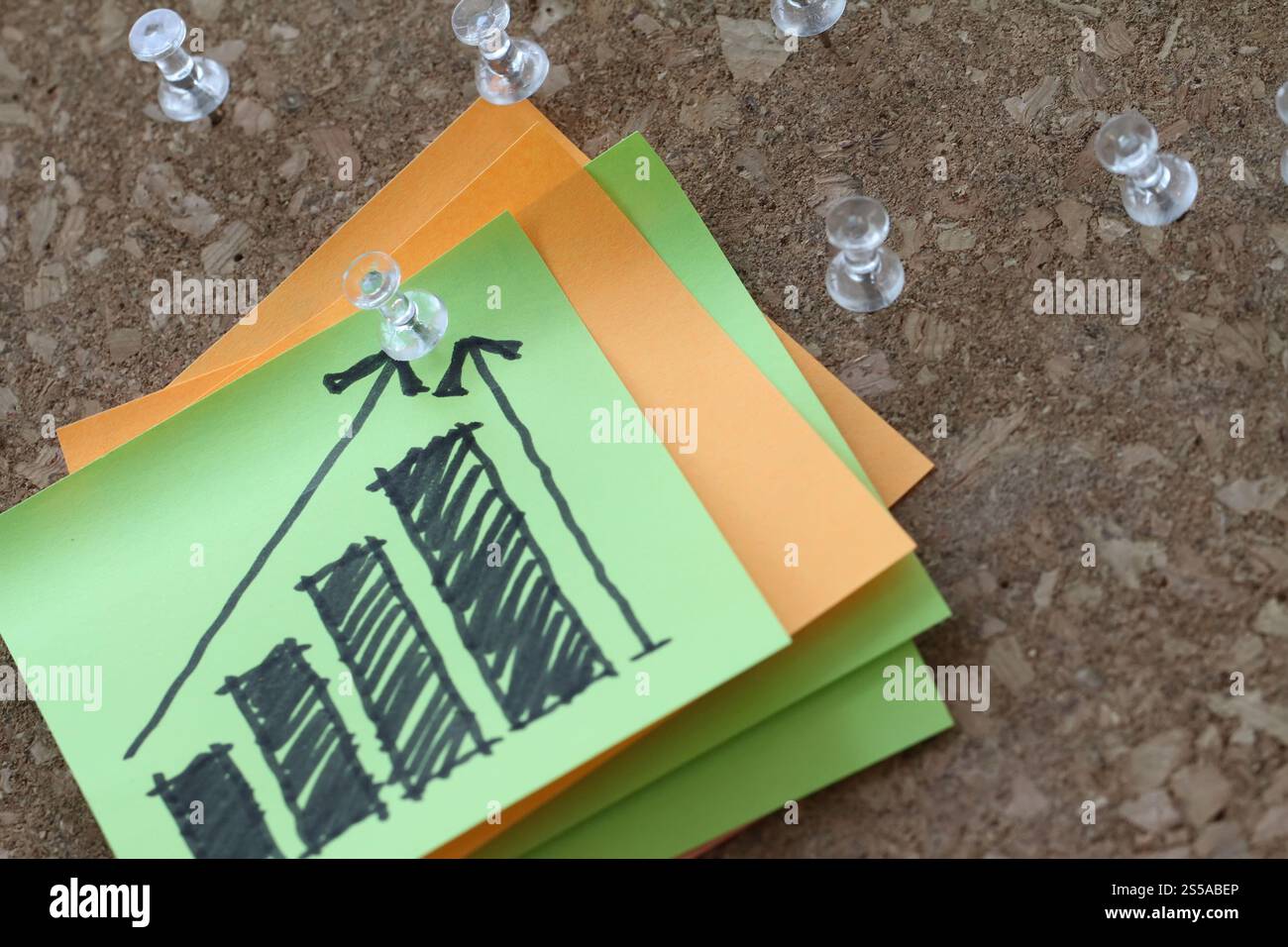 close up of pin and hand drawn business strategy graph chart on sticky ...